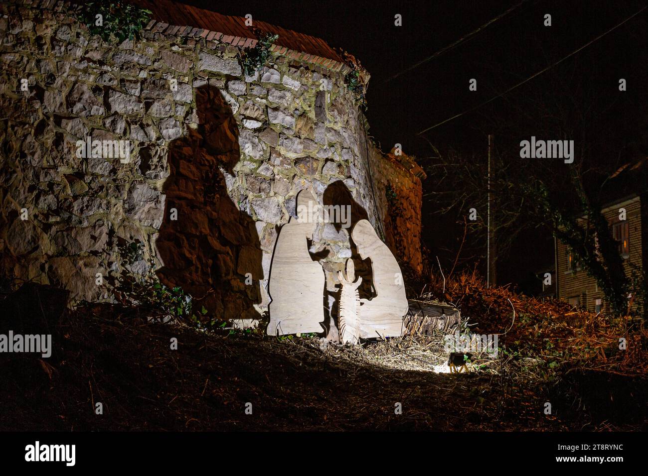 At the foot of a stone wall, a Christmas nativity scene made of ...