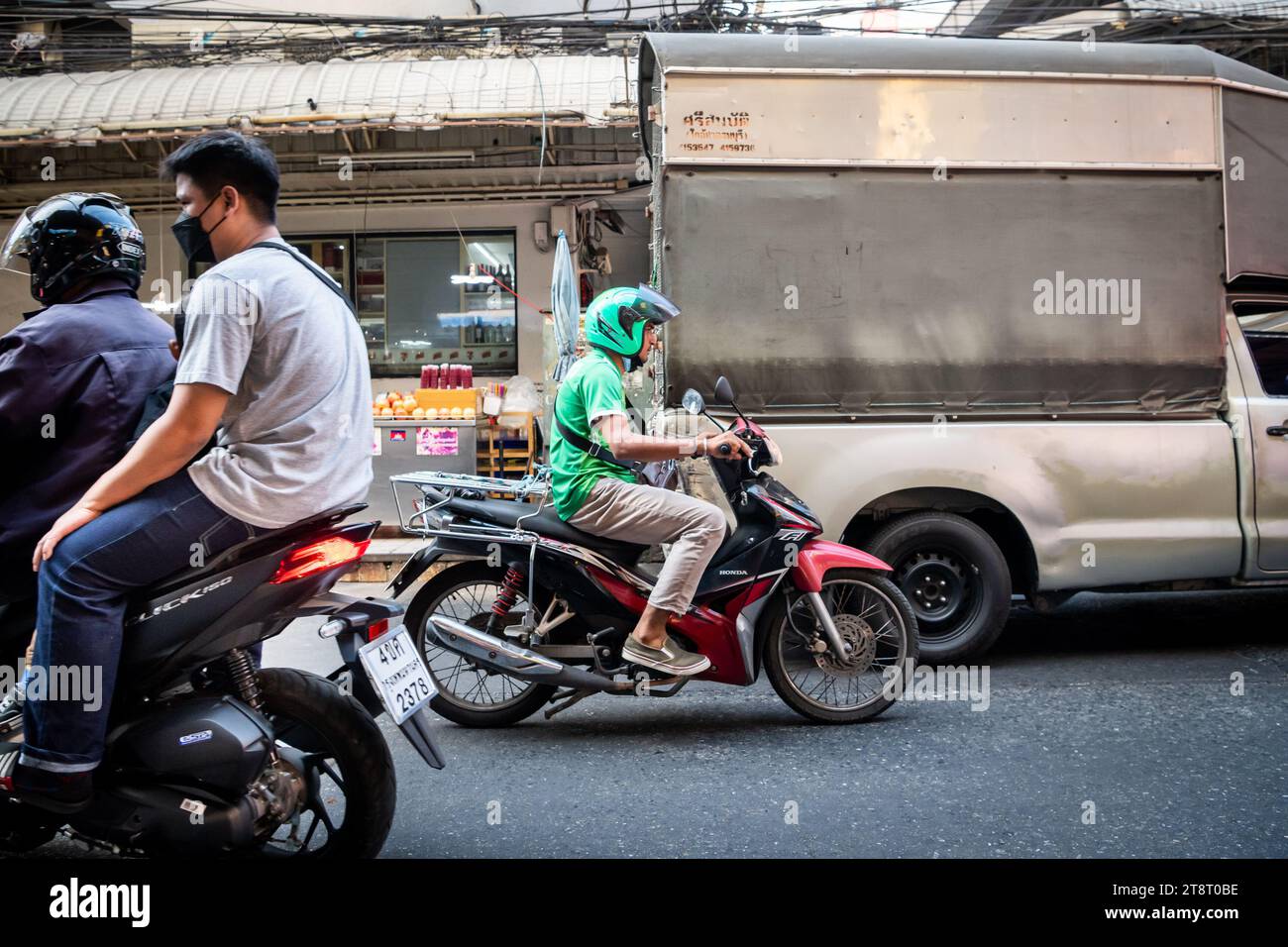 Pedestrians, shoppers and market workers busily go about their business ...