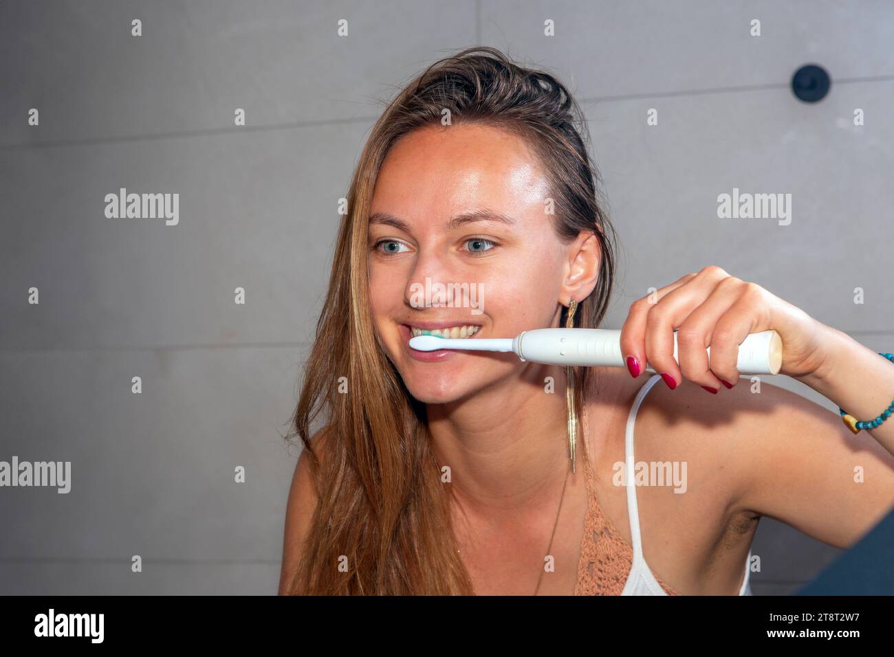 nice woman brushing her teeth with an electric toothbrush Stock Photo ...
