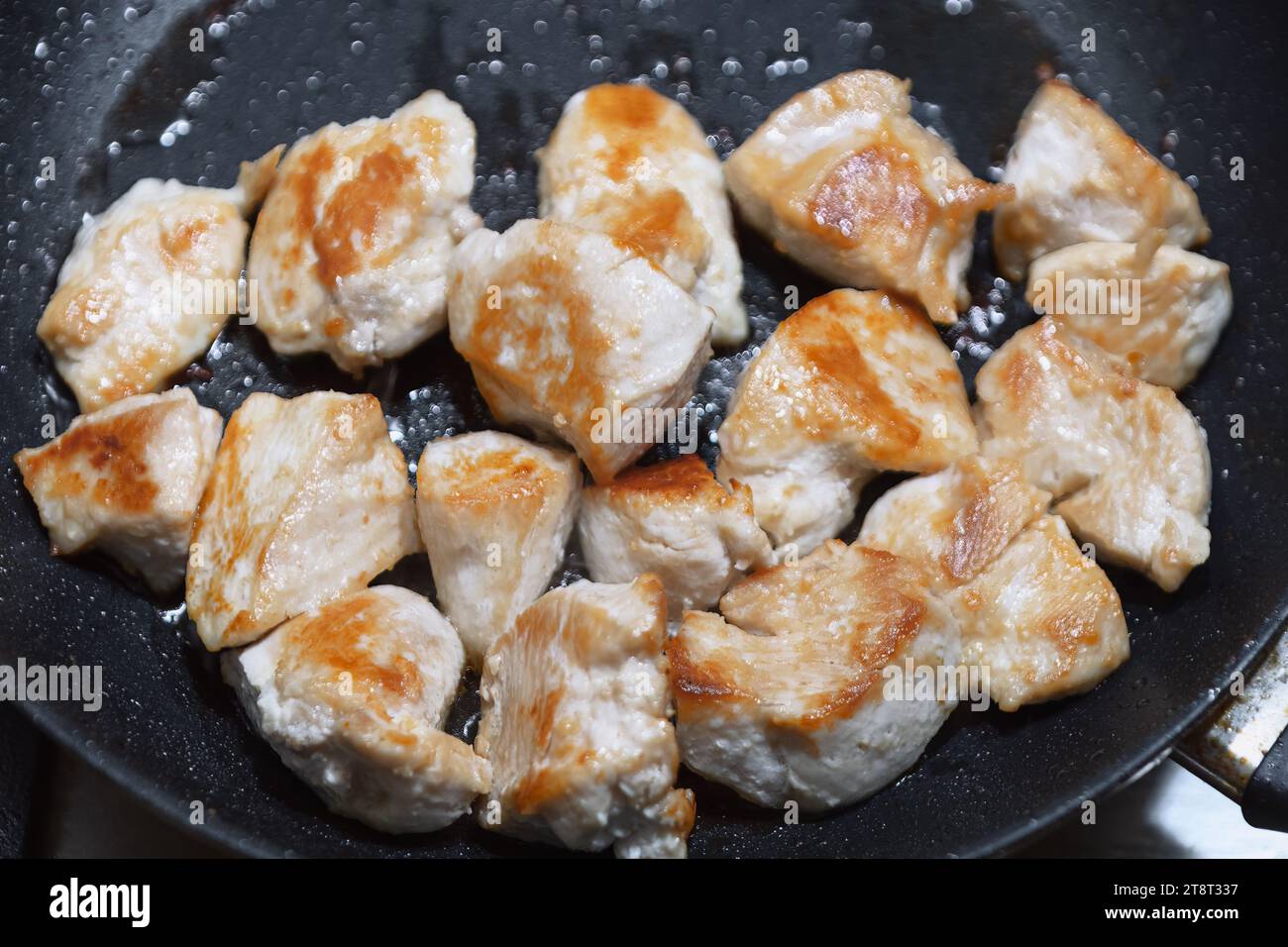 Chicken fillet fried in a frying pan, close-up. Details of the cooking ...