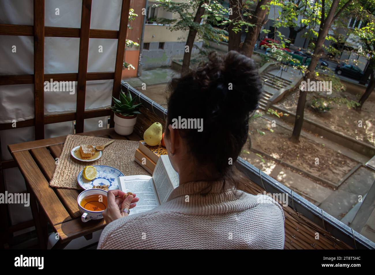 Picture of young woman enjoying quiet morning time at balcony, having a ...