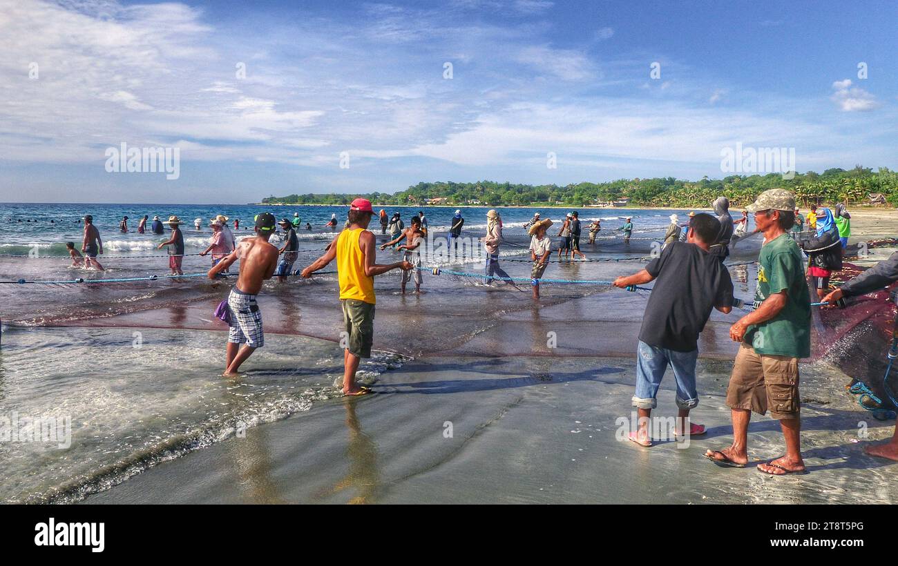 It takes a village. Philippines, Fishermen pulling ashore there nets ...