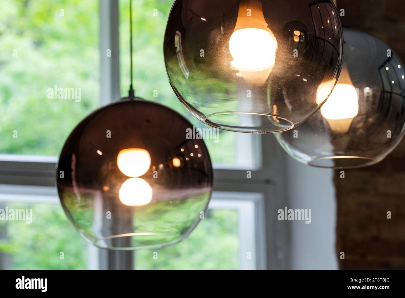 Round glass lampshades with glowing tungsten lamps inside, close-up ...