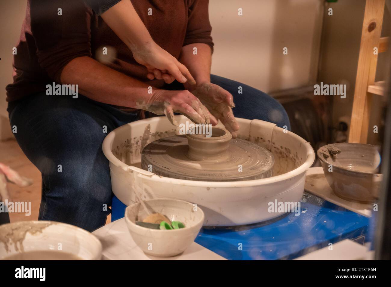 Potters wheel with hands forming clay to art Stock Photo - Alamy