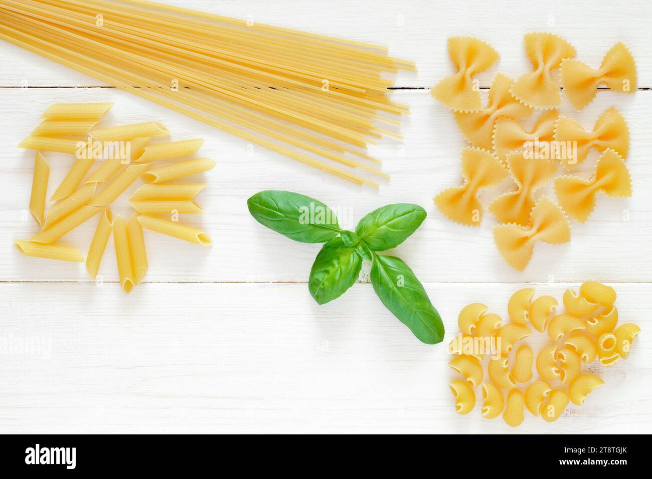 Pasta, set of raw farfalle, spaghetti, pipe, maccheroni, green leaf ...