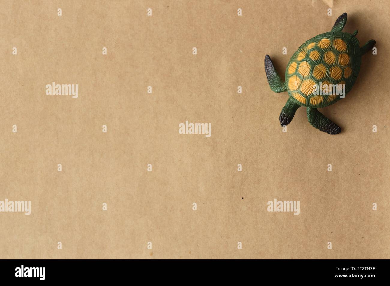 green toy turtle on a brown paper background Stock Photo - Alamy