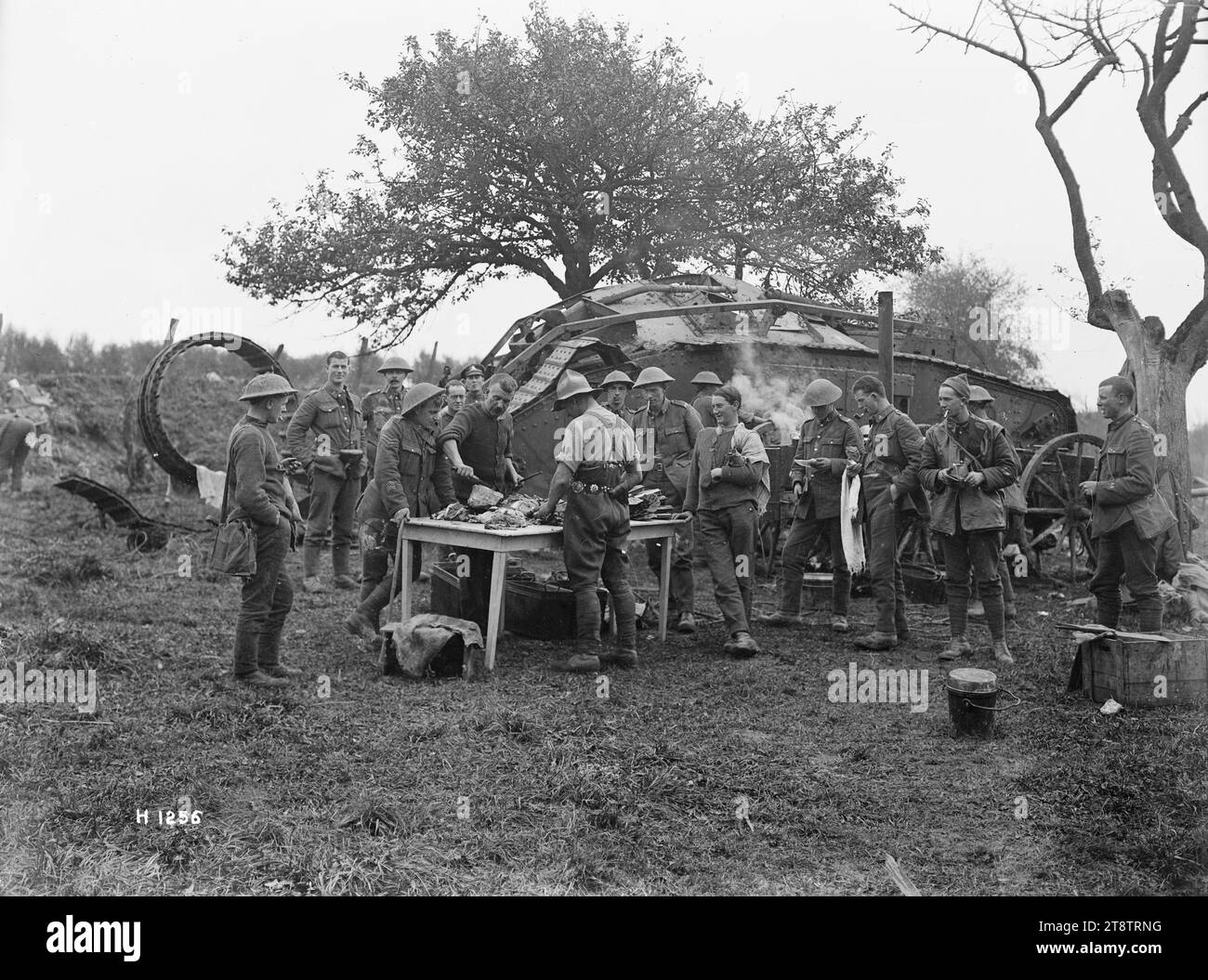 World War I soldiers preparing a meal near a damaged German tank ...