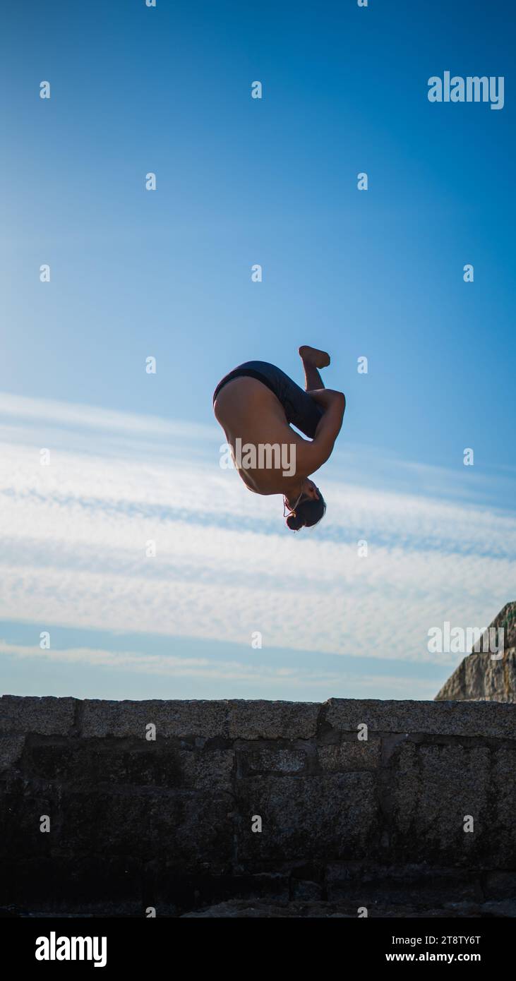 Boy jumping off wall into sea hi-res stock photography and images - Alamy