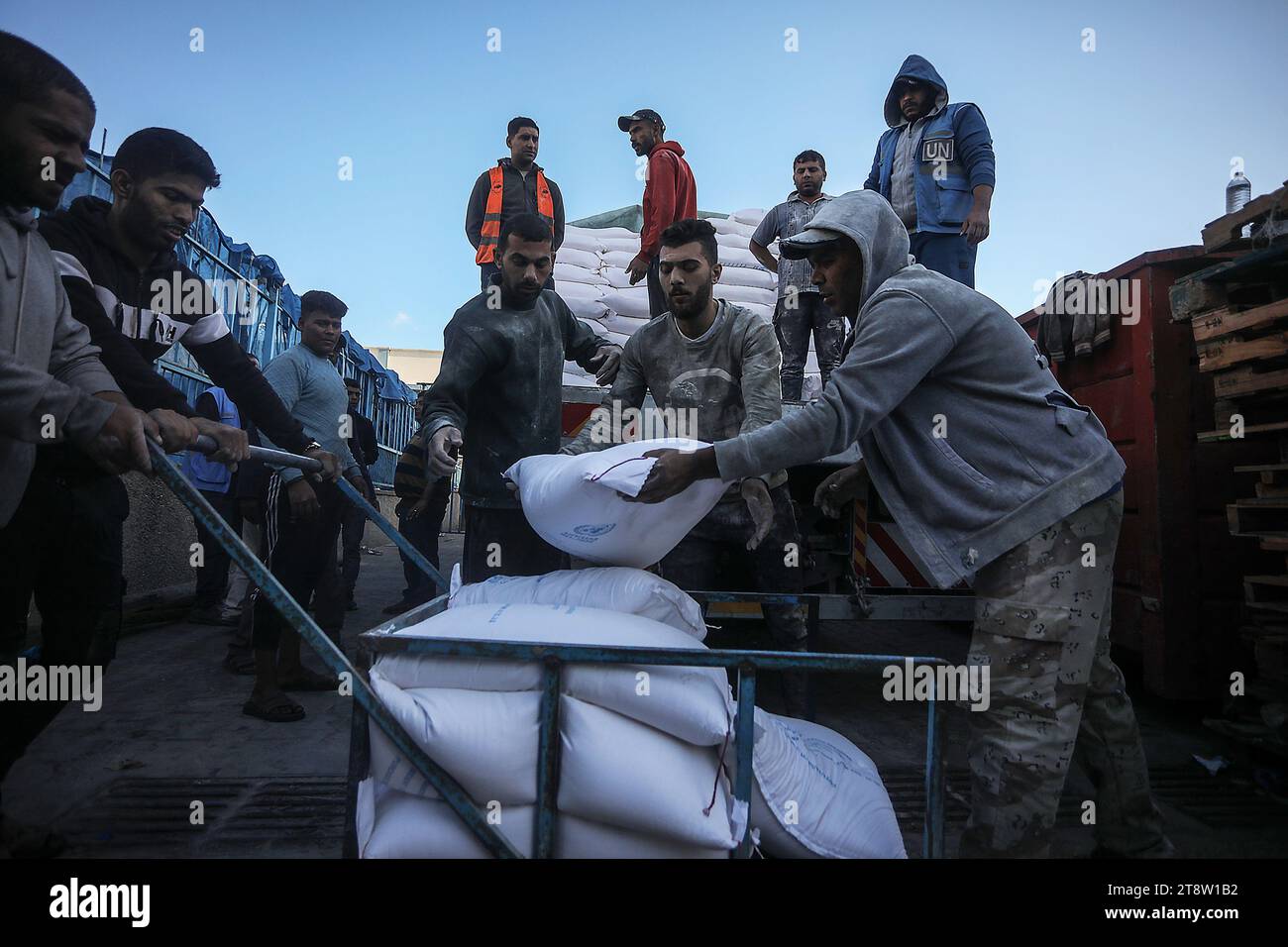 Palestinians receive bags of flour at the United Nations Relief and ...