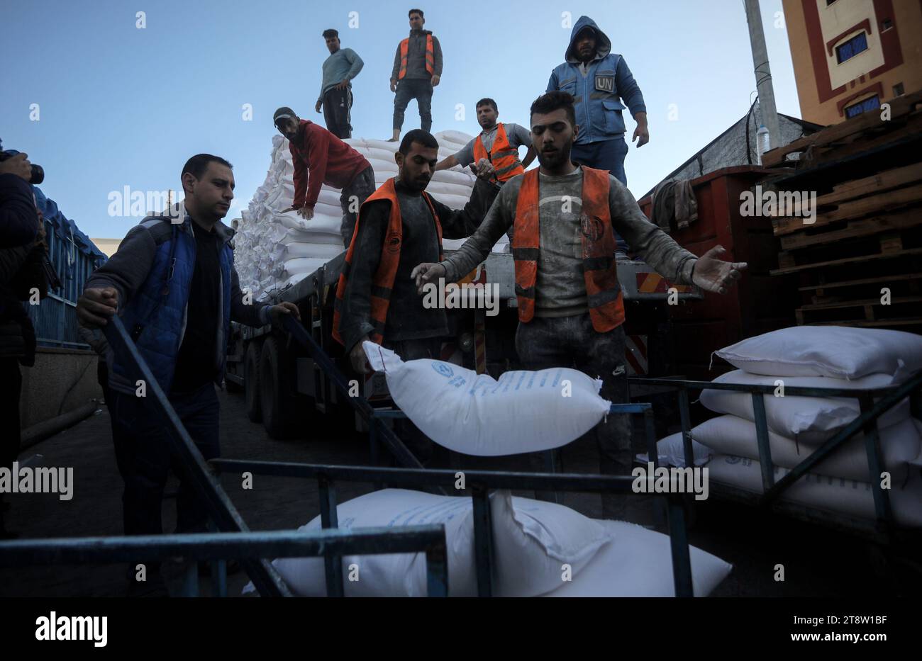 Palestinians receive bags of flour at the United Nations Relief and ...