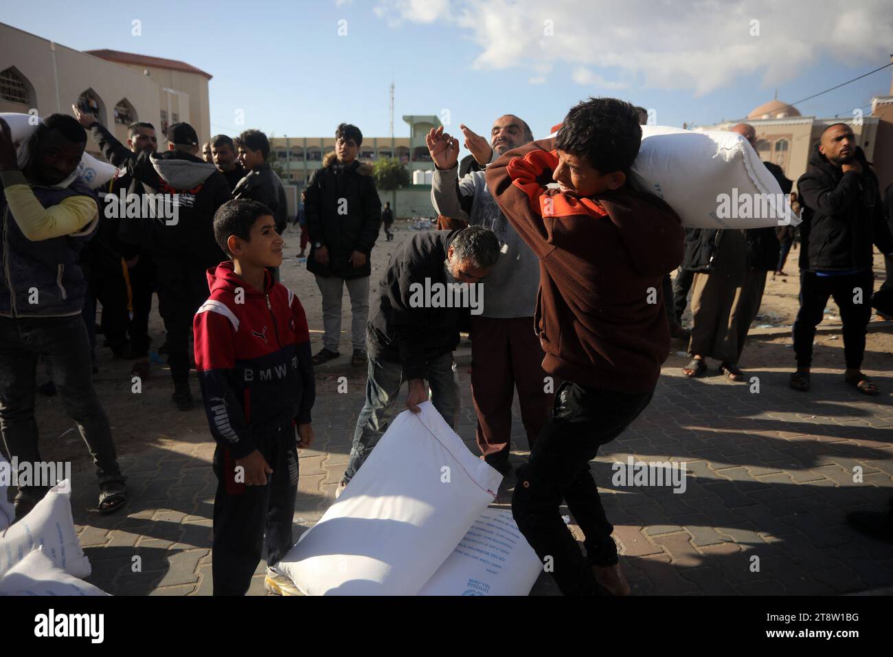 Palestinians receive bags of flour at the United Nations Relief and ...