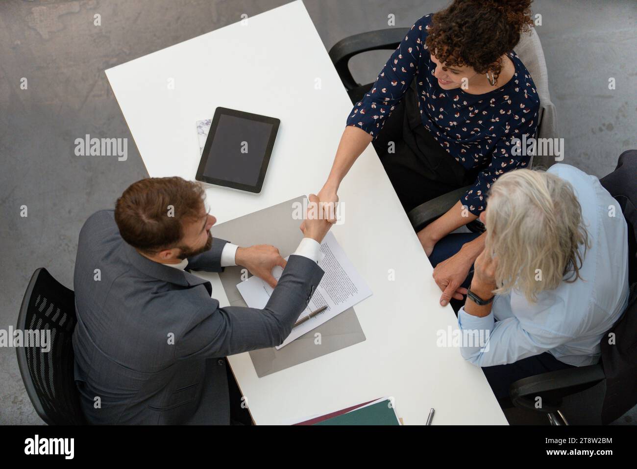 Adult couple shaking hands with lawyer after signing contract Stock ...