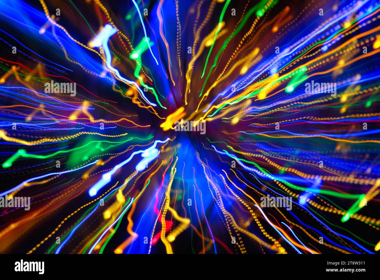 Blurred multi coloured light patterns streaks against a dark background ...