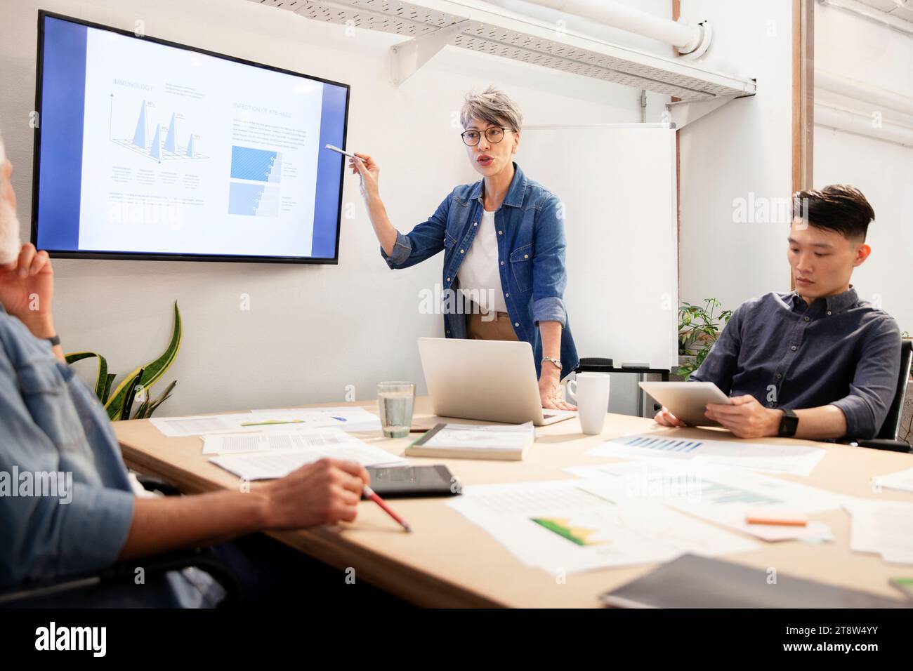 Female project manager discussing over business charts with coworker ...