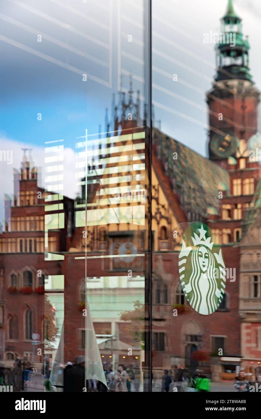 The Starbucks logo on the cafe window with the blurry reflection of the ...