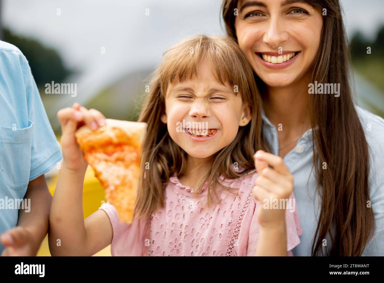 Cheerful mom with her little daughter eating pizza Stock Photo - Alamy