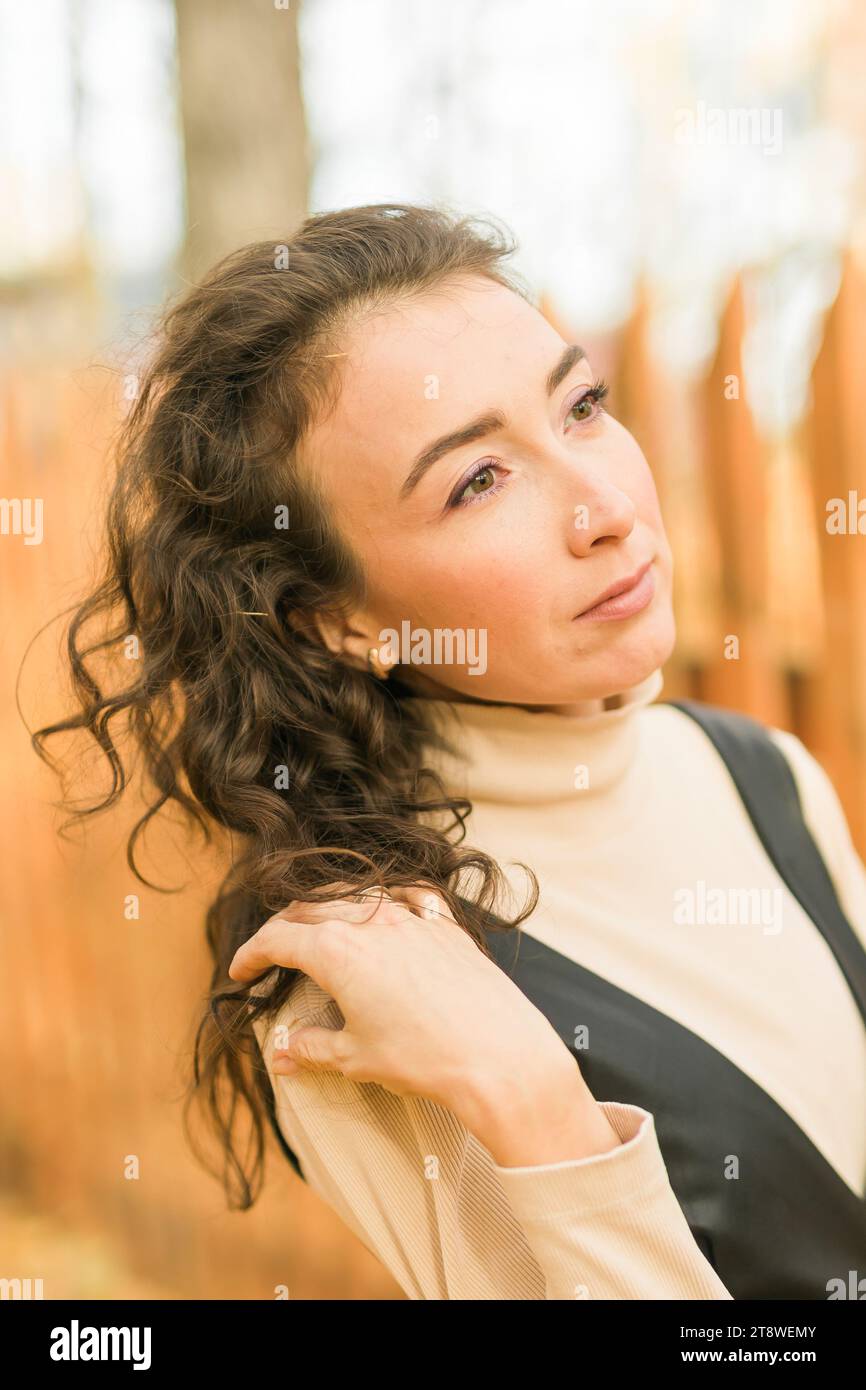 Autumn portrait of a beautiful happy curly woman in fall season ...