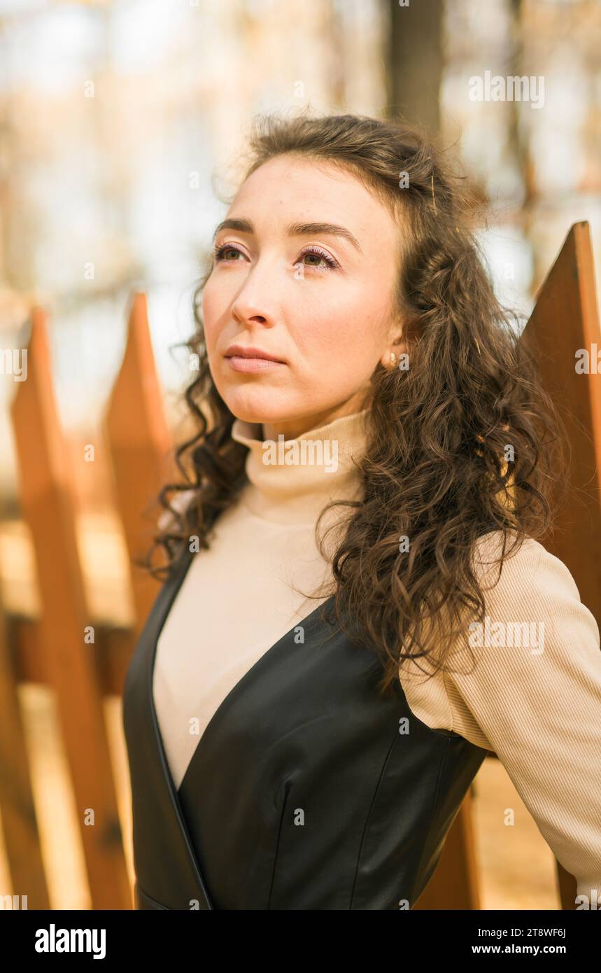 Autumn portrait of a beautiful happy curly woman in fall season ...