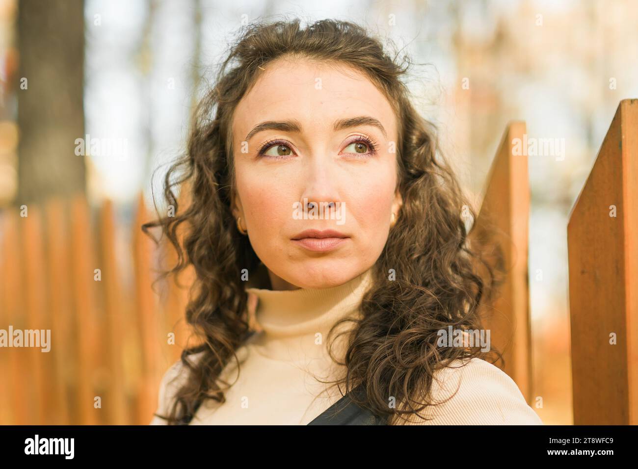 Autumn portrait of a beautiful happy curly woman in fall season ...