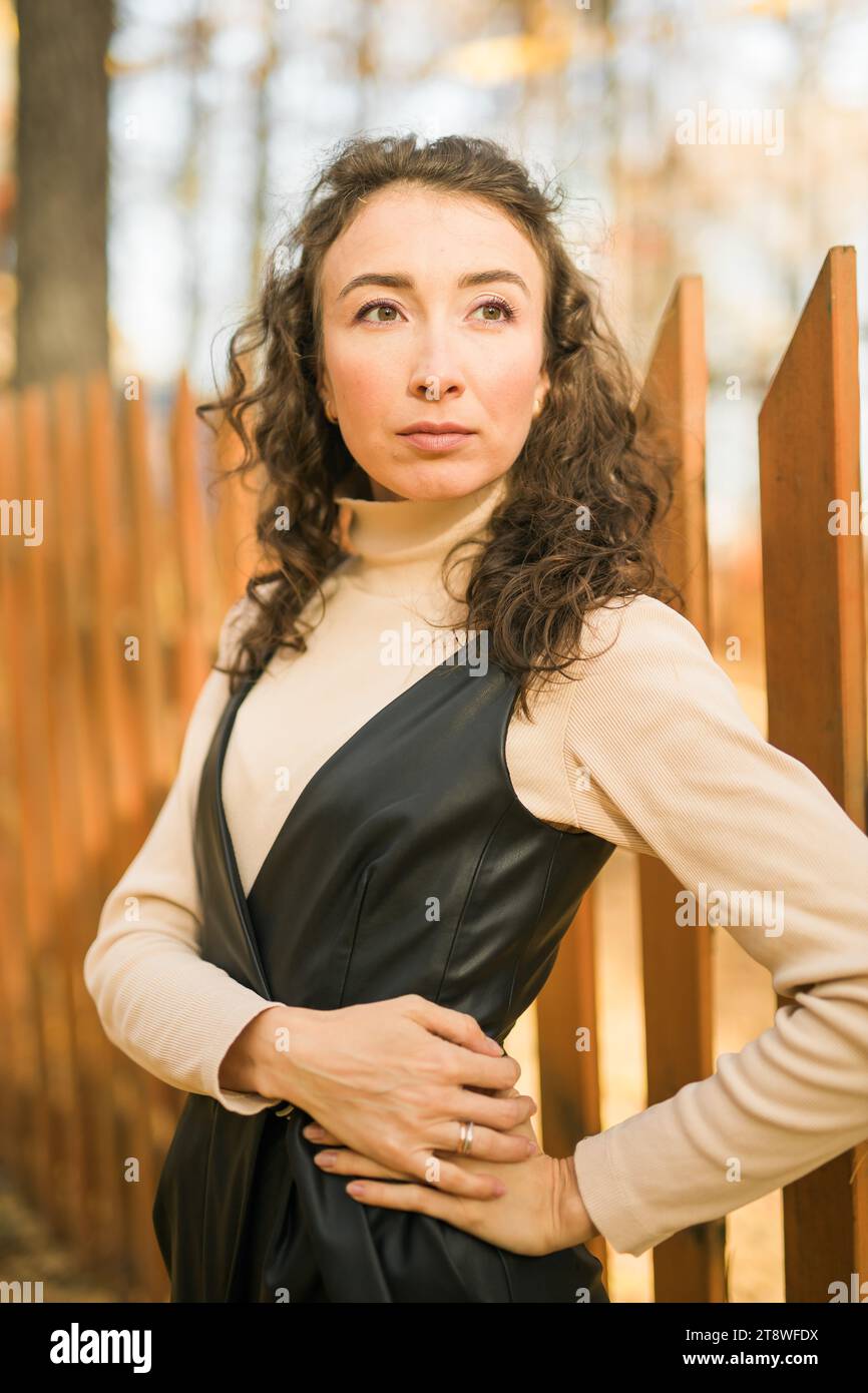Autumn portrait of a beautiful happy curly woman in fall season ...