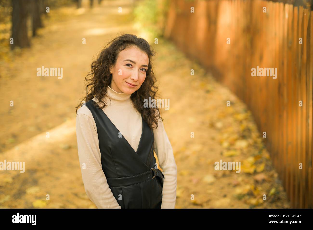 Autumn portrait of a beautiful happy curly woman in fall season copy ...
