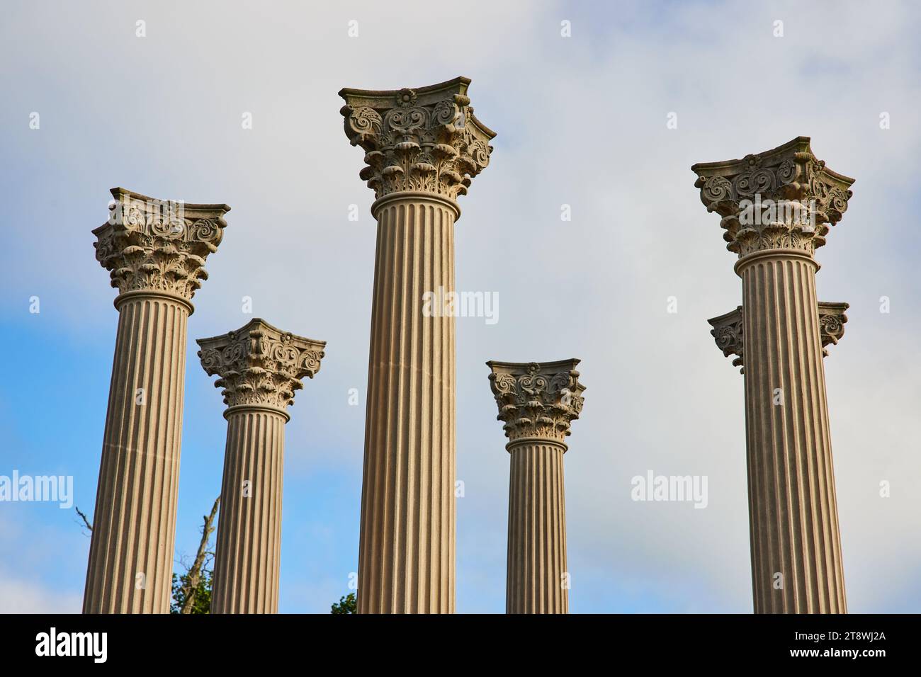 Greek pillars rising toward white cloud in blue sky, architecture at ...