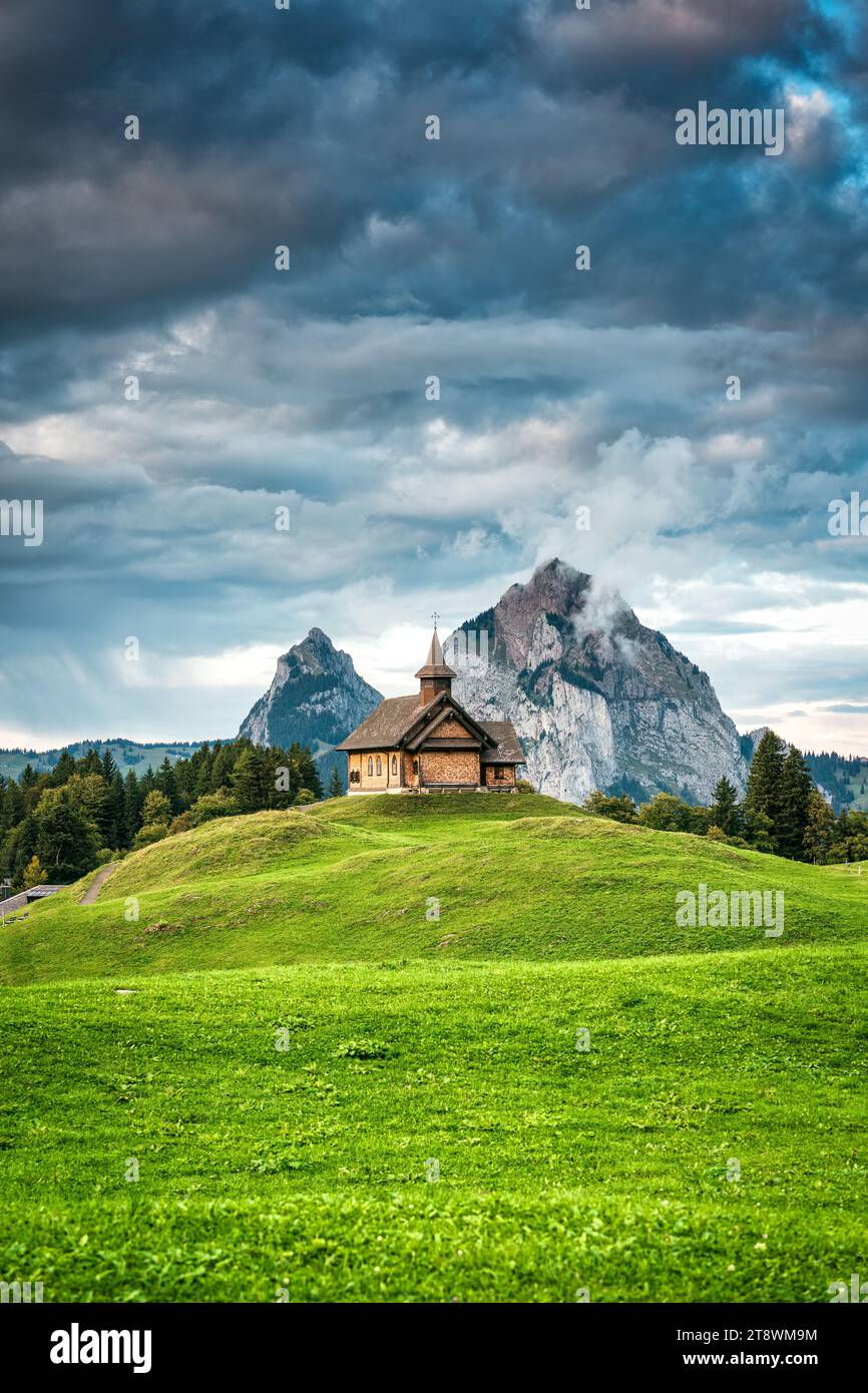 Wooden Stoos church on green hill in front of Grosser Mythen mountain ...