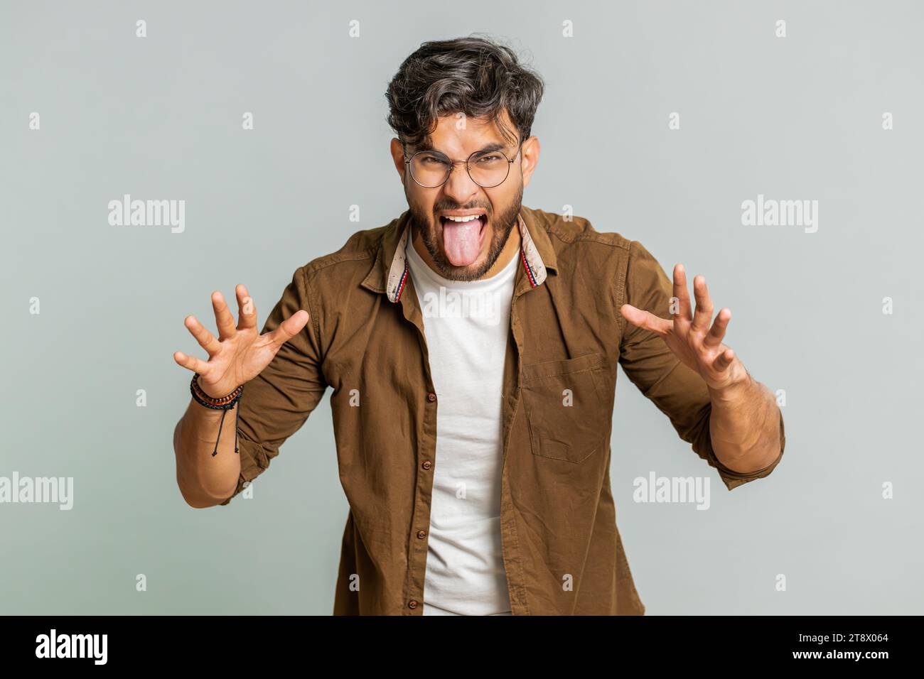 Playful Indian Young Man Showing Tongue Making Faces At Camera Fooling