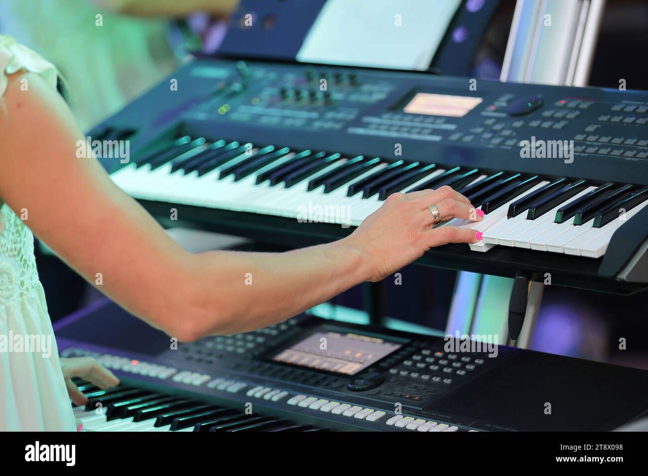 Closeup of a woman's hand playing a double keyboard at a concert Stock ...