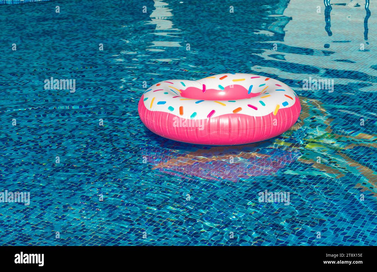 A rubber bitten donut with caramel sprinkles floats in the clear blue ...