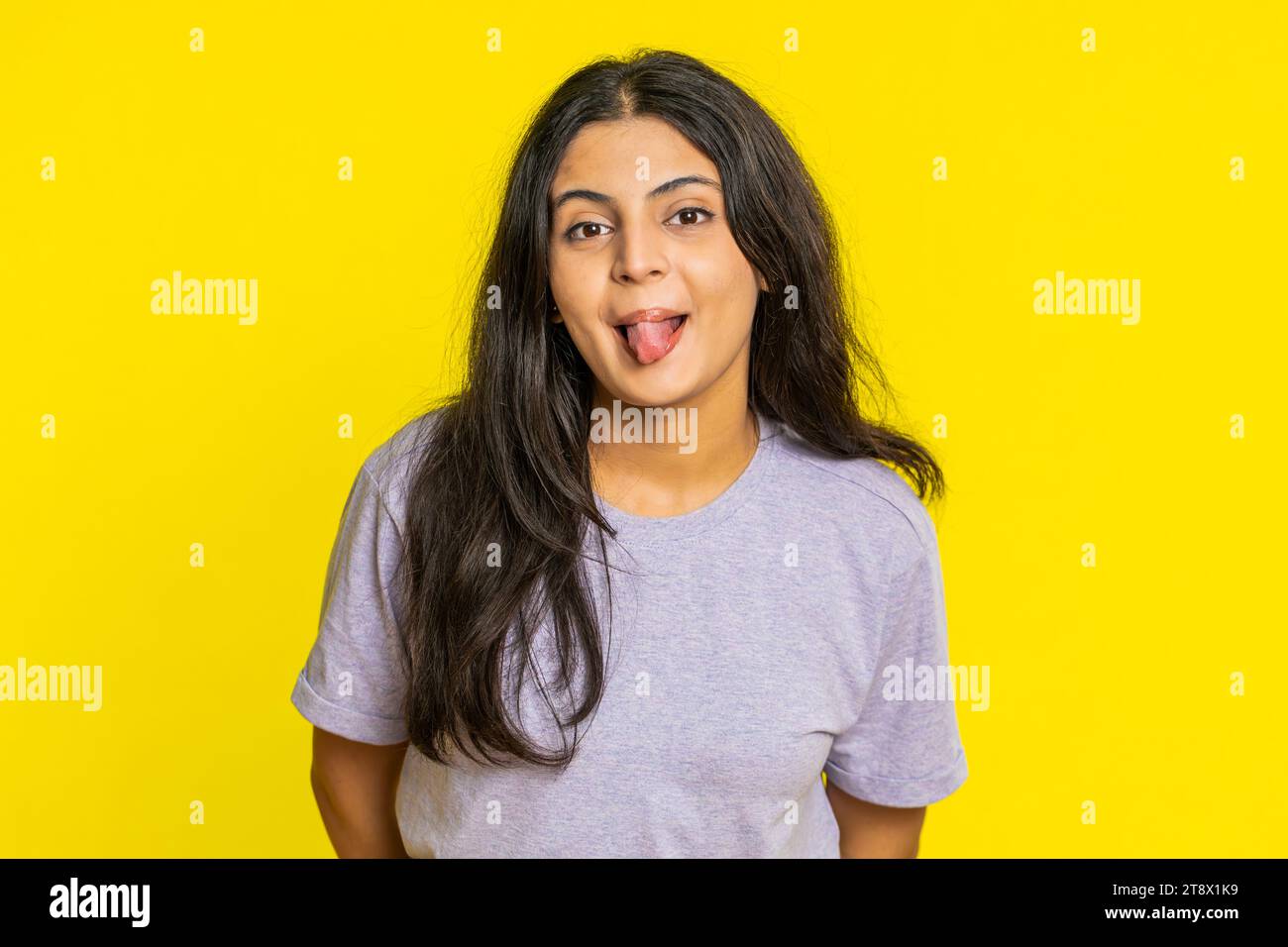 Funny comical playful Indian young woman making silly facial expressions grimacing fooling ...