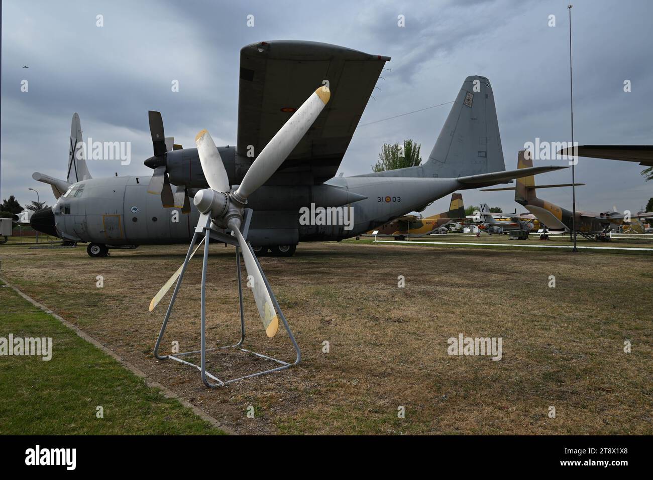 A close-up image of a propeller on top of an airplane in a field, with ...