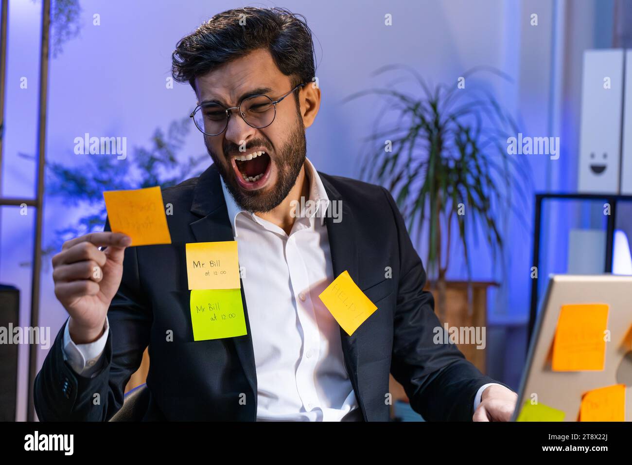 Tired exhausted Indian businessman working on laptop at office with ...