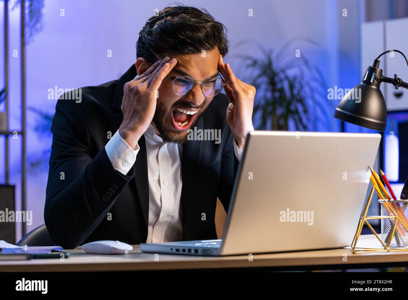 Irritated tired Indian business man while working on laptop, unexpected ...