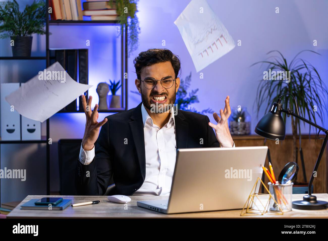 Stressed Indian businessman working looking at unpaid bank debt bills ...