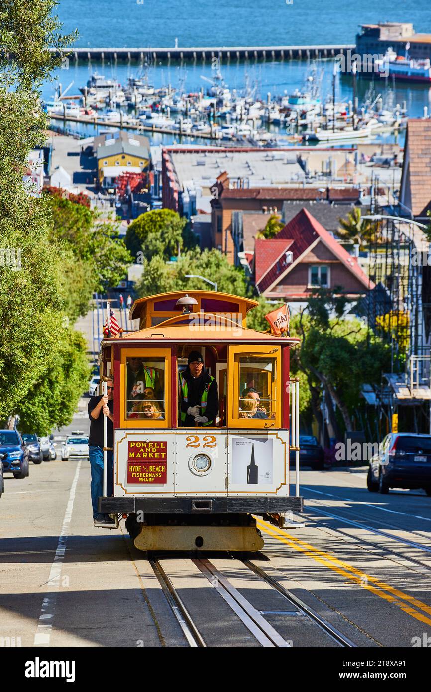 Trolley driver coming up steep hill on tracks with San Francisco Bay ...