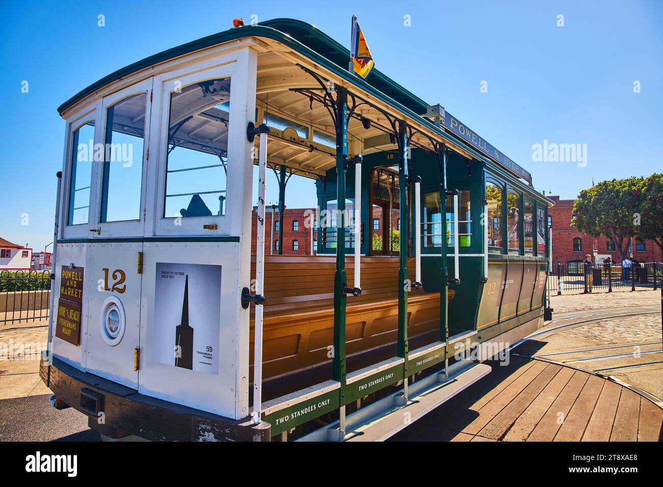 Open air green trolley streetcar at end of path with rotating platform ...