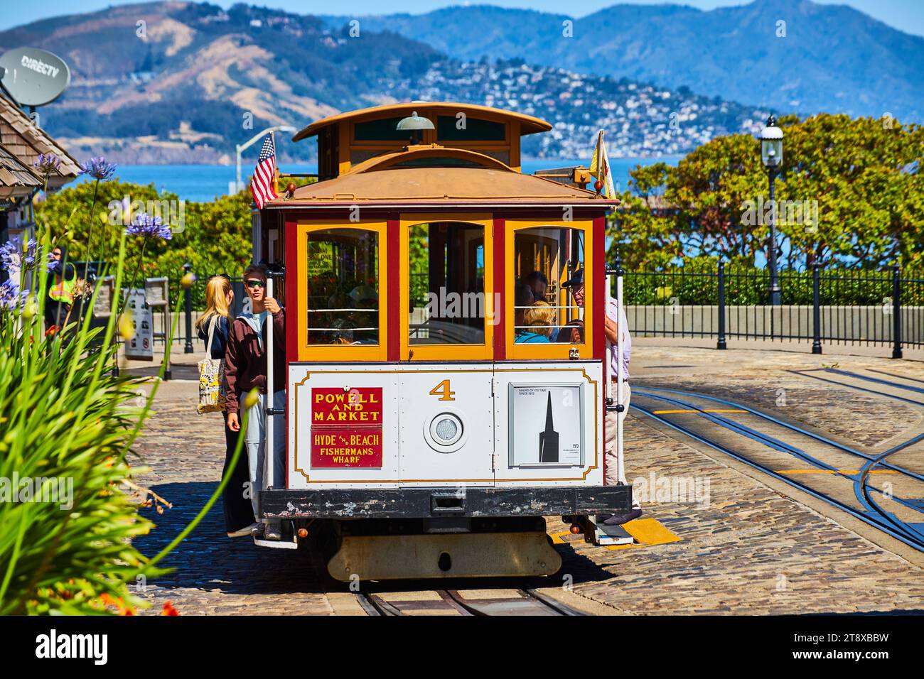 Tourists holding white on trolley streetcar on flat road with San ...
