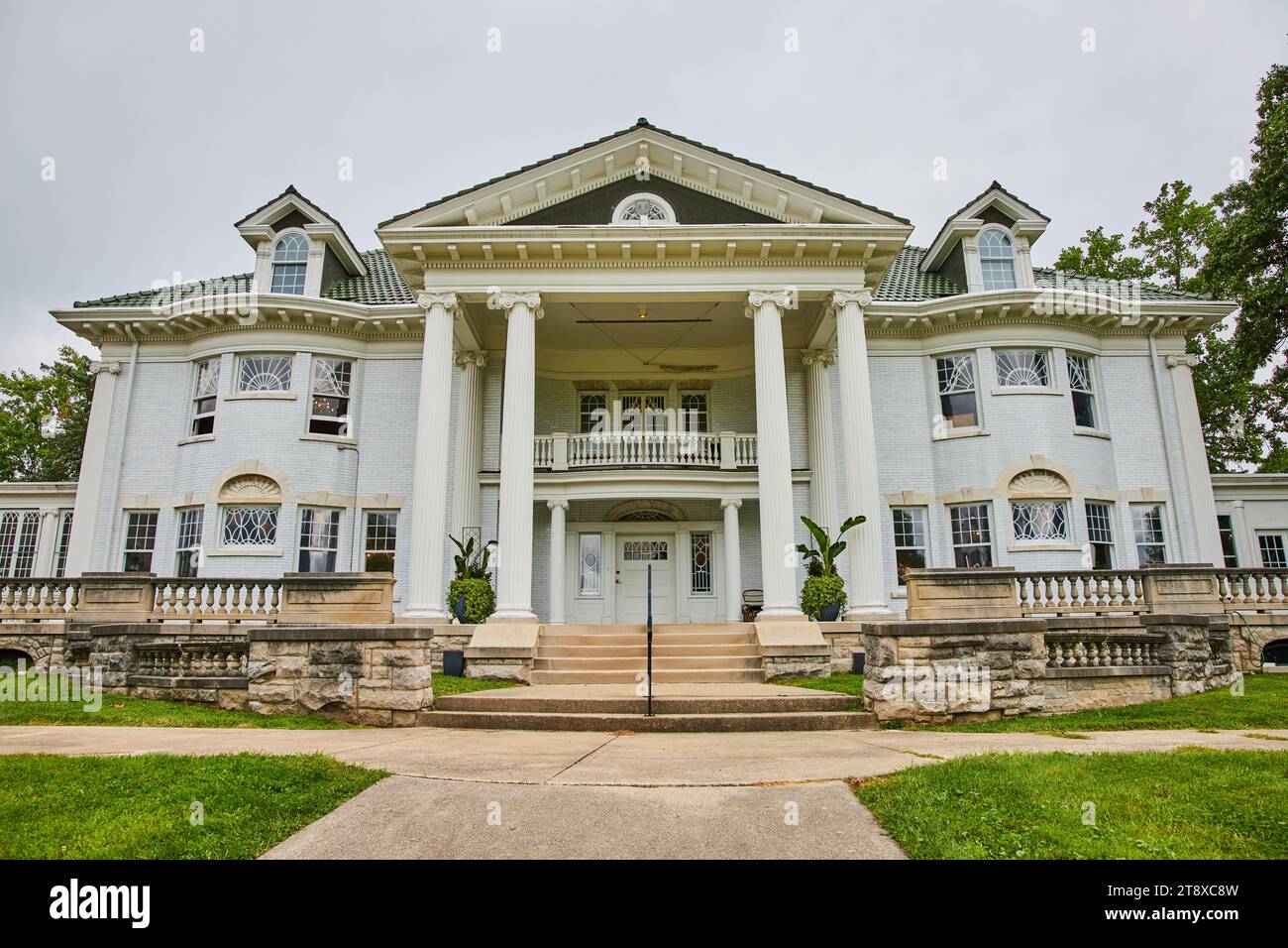 Large white mansion with sidewalk leading to pillars and front door ...