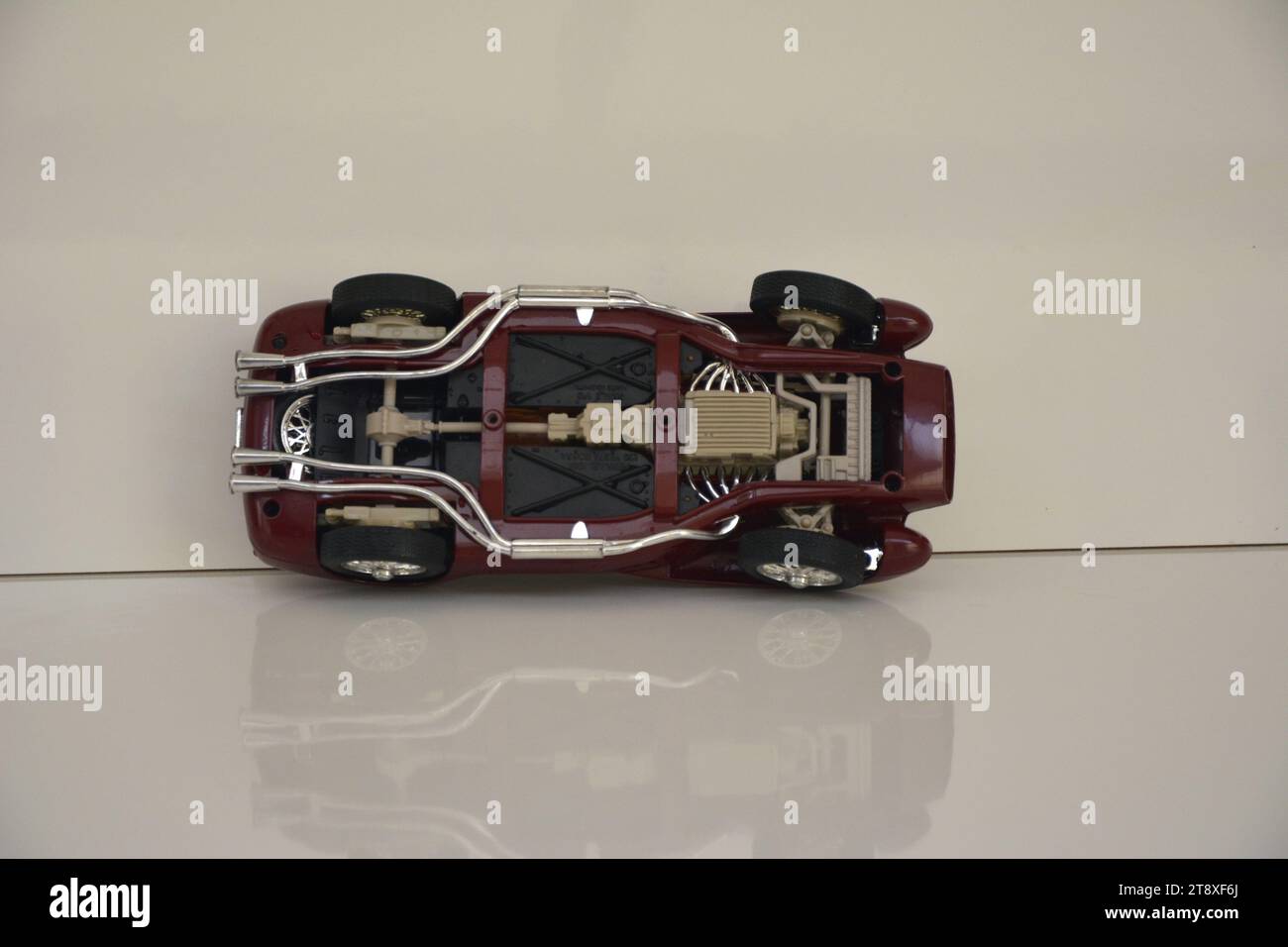 Miniature car of famous brand in red color with open trunk. White ...