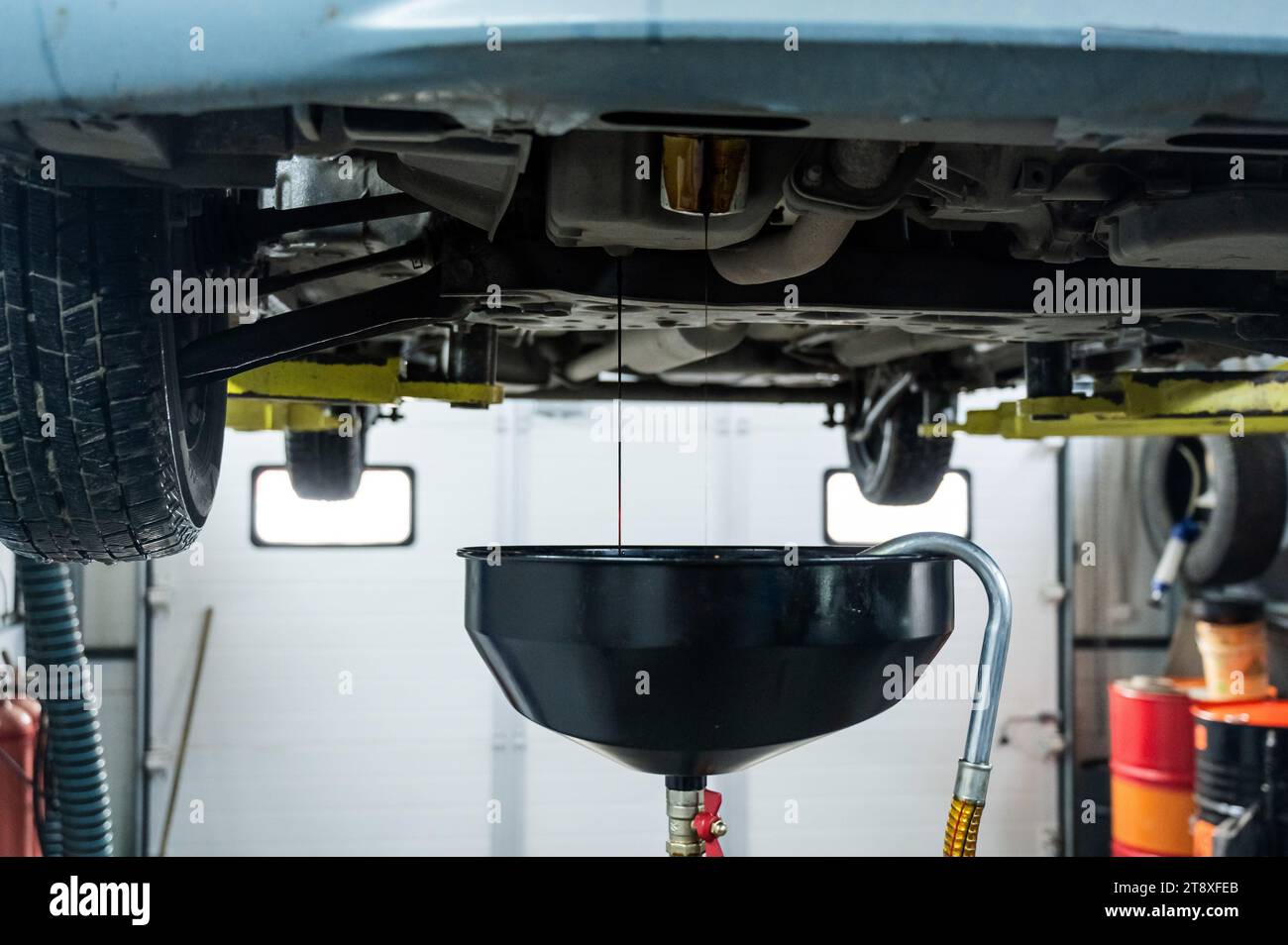 The process of changing the oil in a car engine. Draining old dark used ...