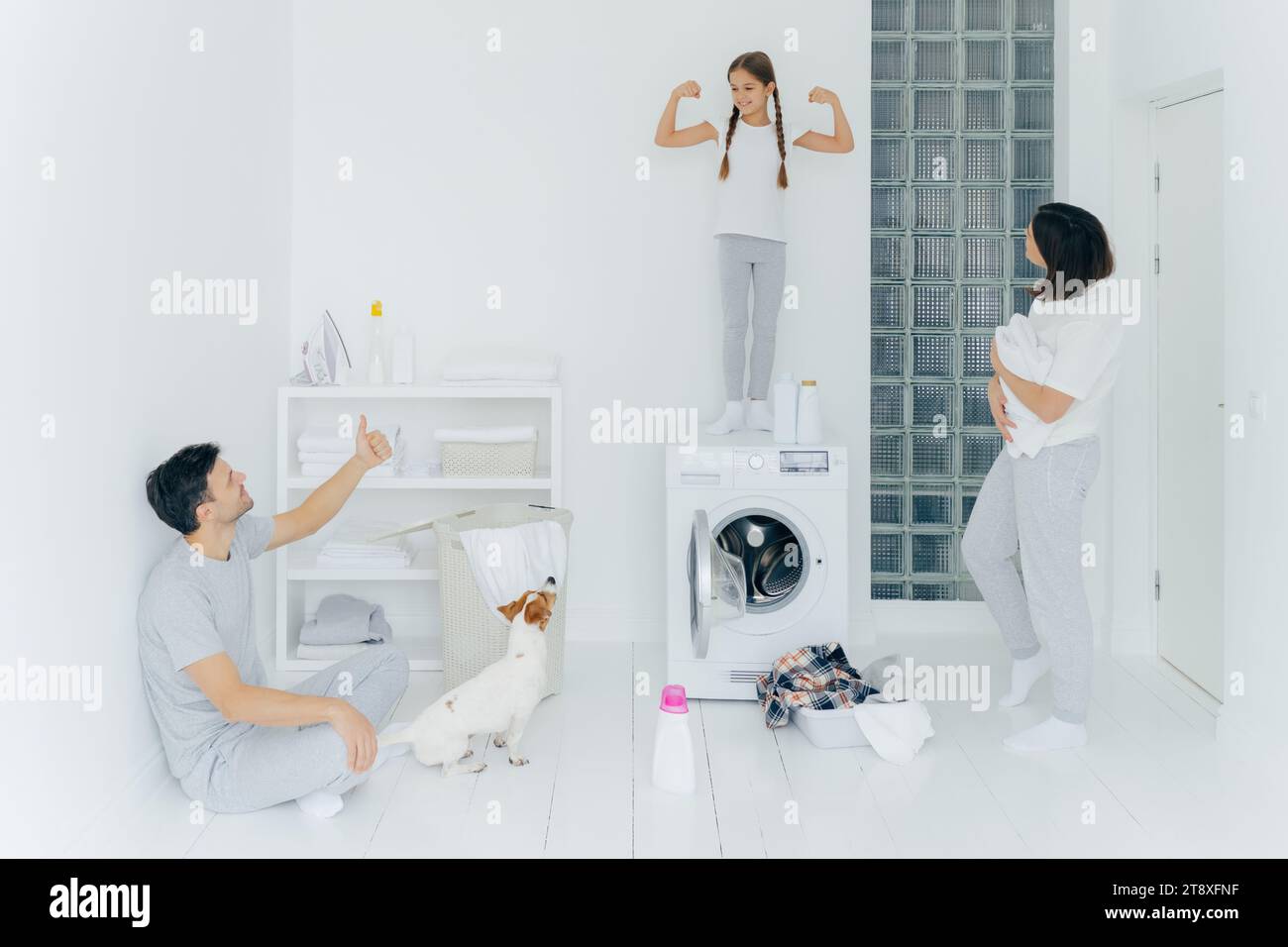 Family fun during laundry time with a child playing, a dog, and a ...