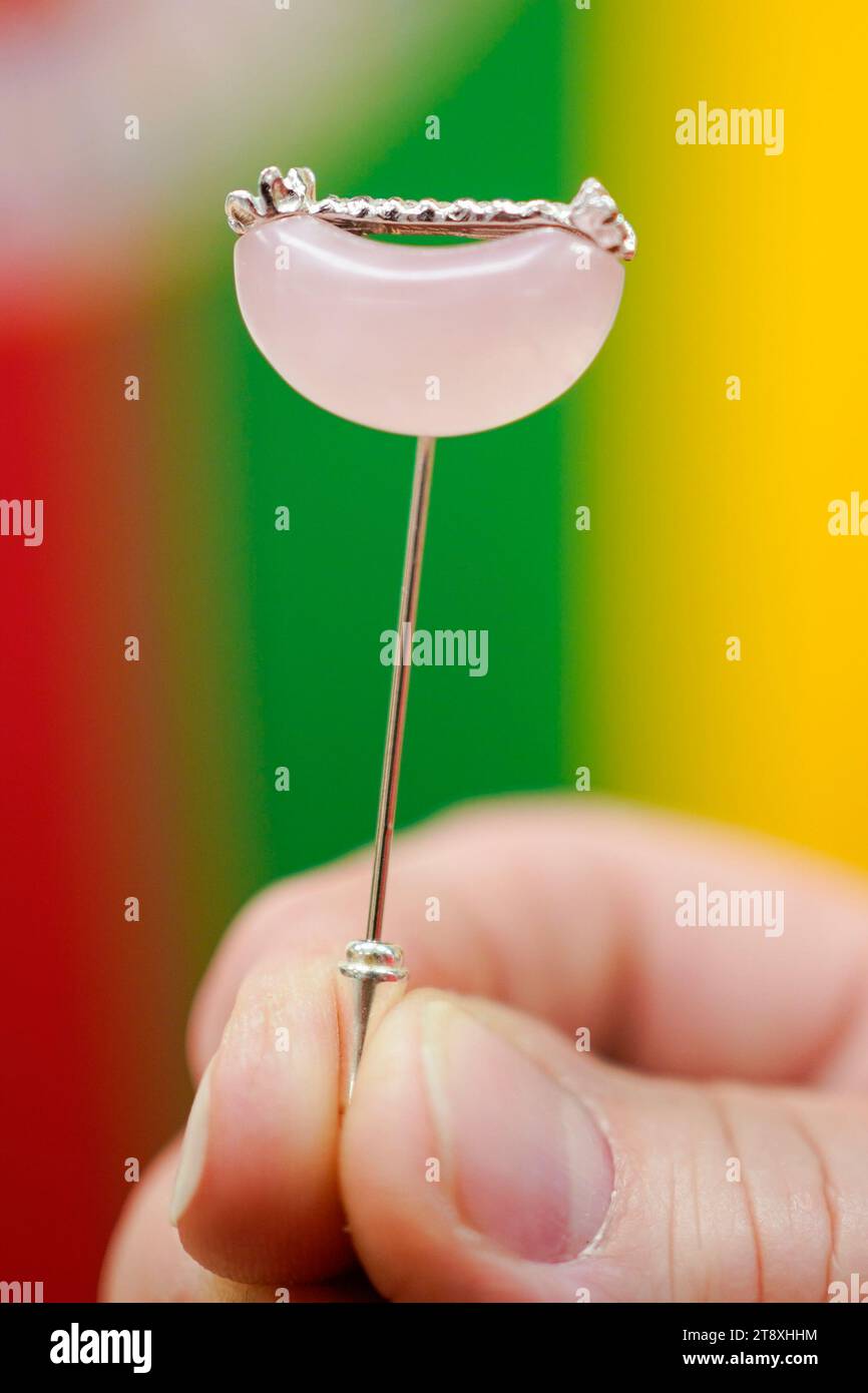 Schifferstadt, Germany. 21st Nov, 2023. Two fingers hold a pin with the ...