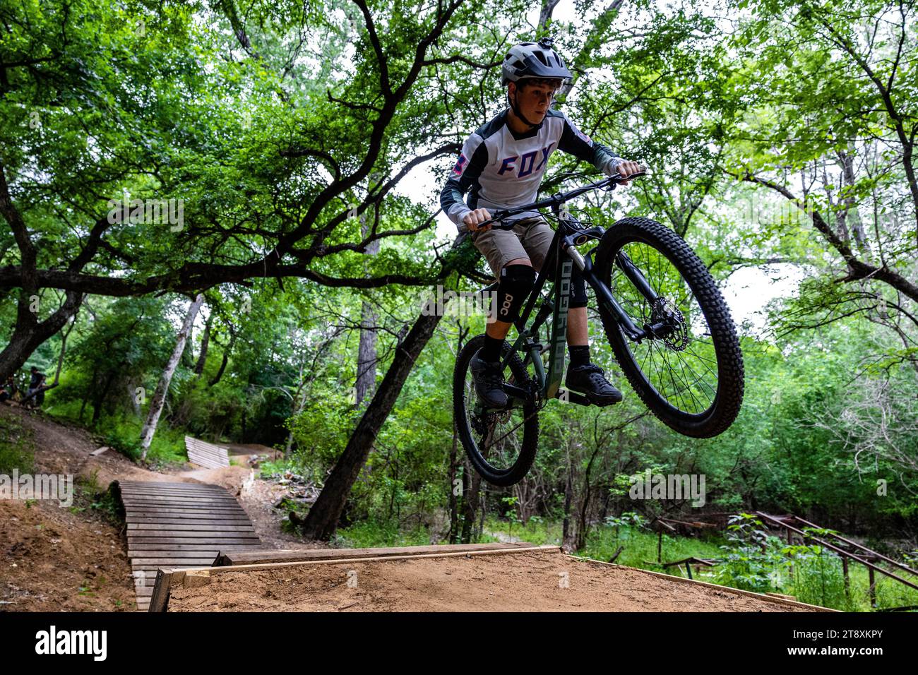 A person performing an extreme biking maneuver, launching off a ramp in ...