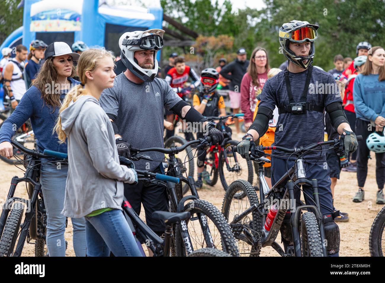A group of people wearing safety helmets and riding bicycles ...