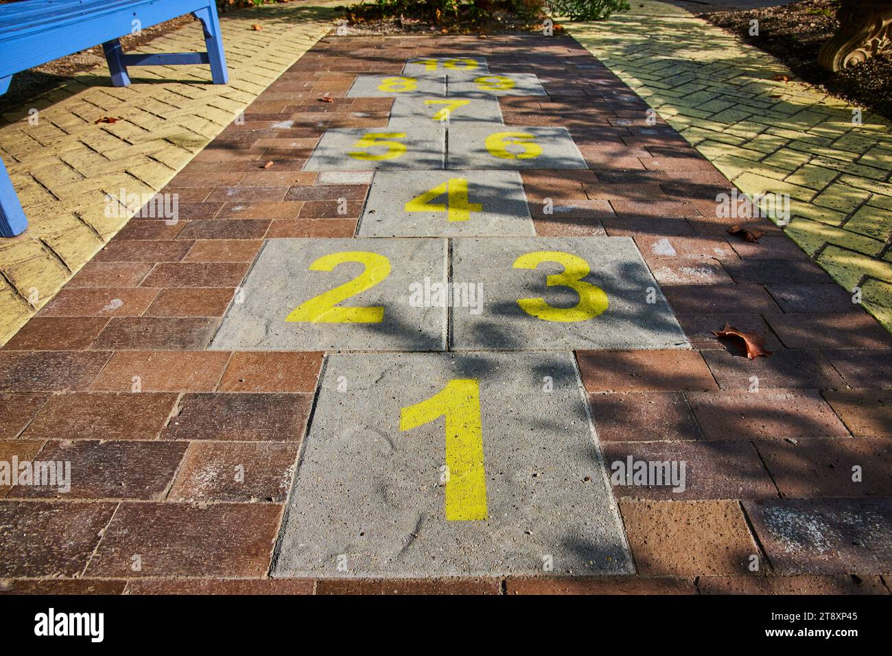 Hopscotch kids game with yellow numbers on brick path at Minnetrista ...