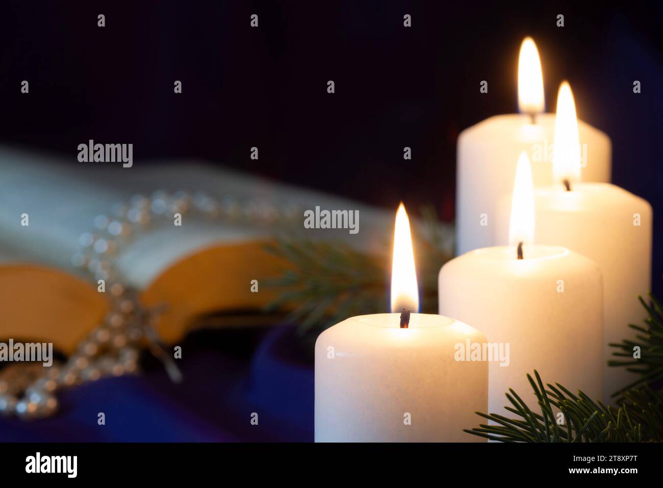 Four burning Advent candles with open Bible and rosary in background ...