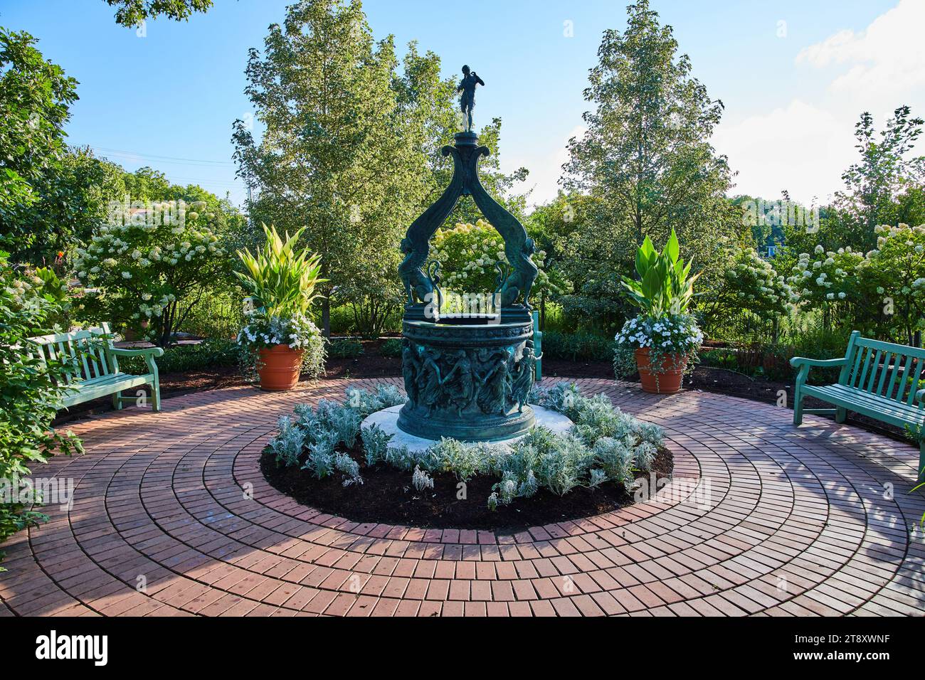 Sunny copper statue in circular brick path in garden, Minnetrista ...