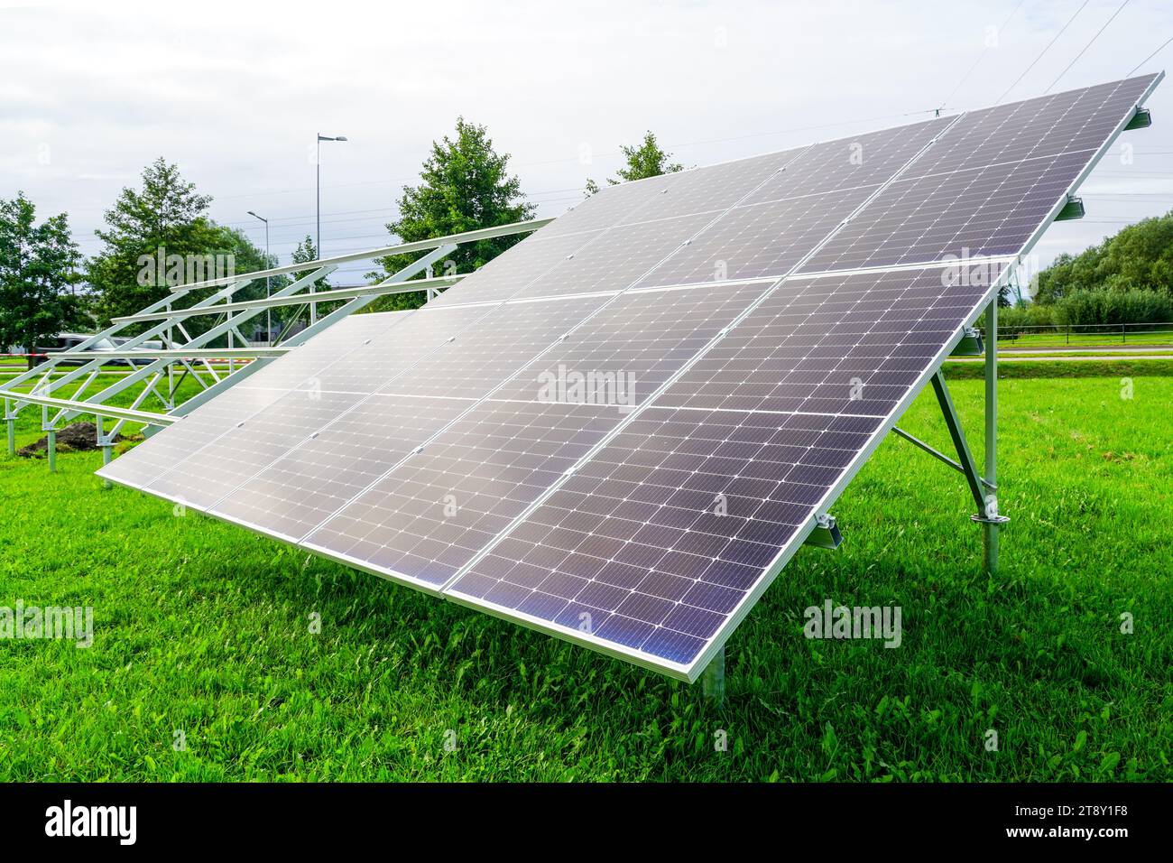Installation of solar panels on metal frames in a green meadow ...