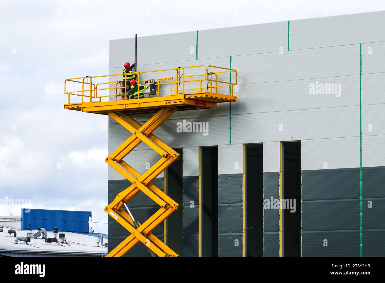 Large elevated aerial scissor lift working platform with workers ...
